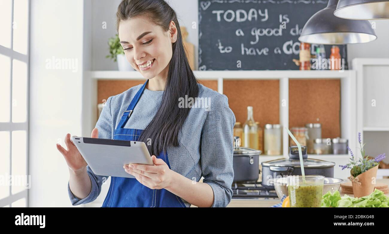 Beautiful woman in the kitchen, waiting with the front of the oven ...