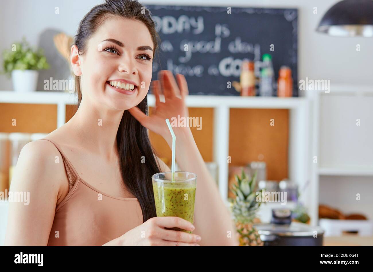 Beautiful woman in the kitchen, waiting with the front of the oven ...