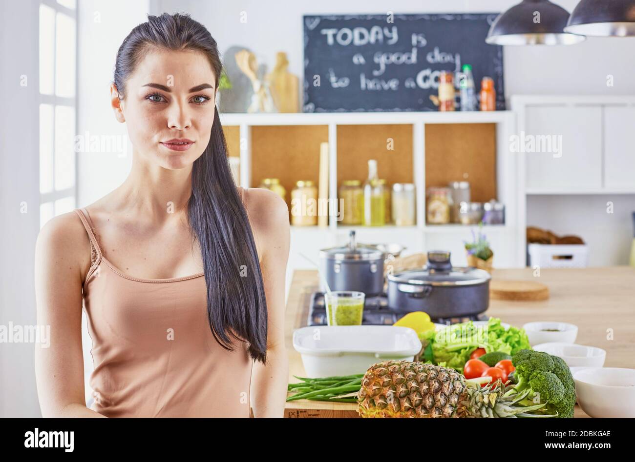 Beautiful woman in the kitchen, waiting with the front of the oven ...