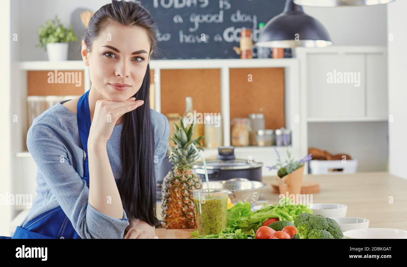 Beautiful woman in the kitchen, waiting with the front of the oven ...
