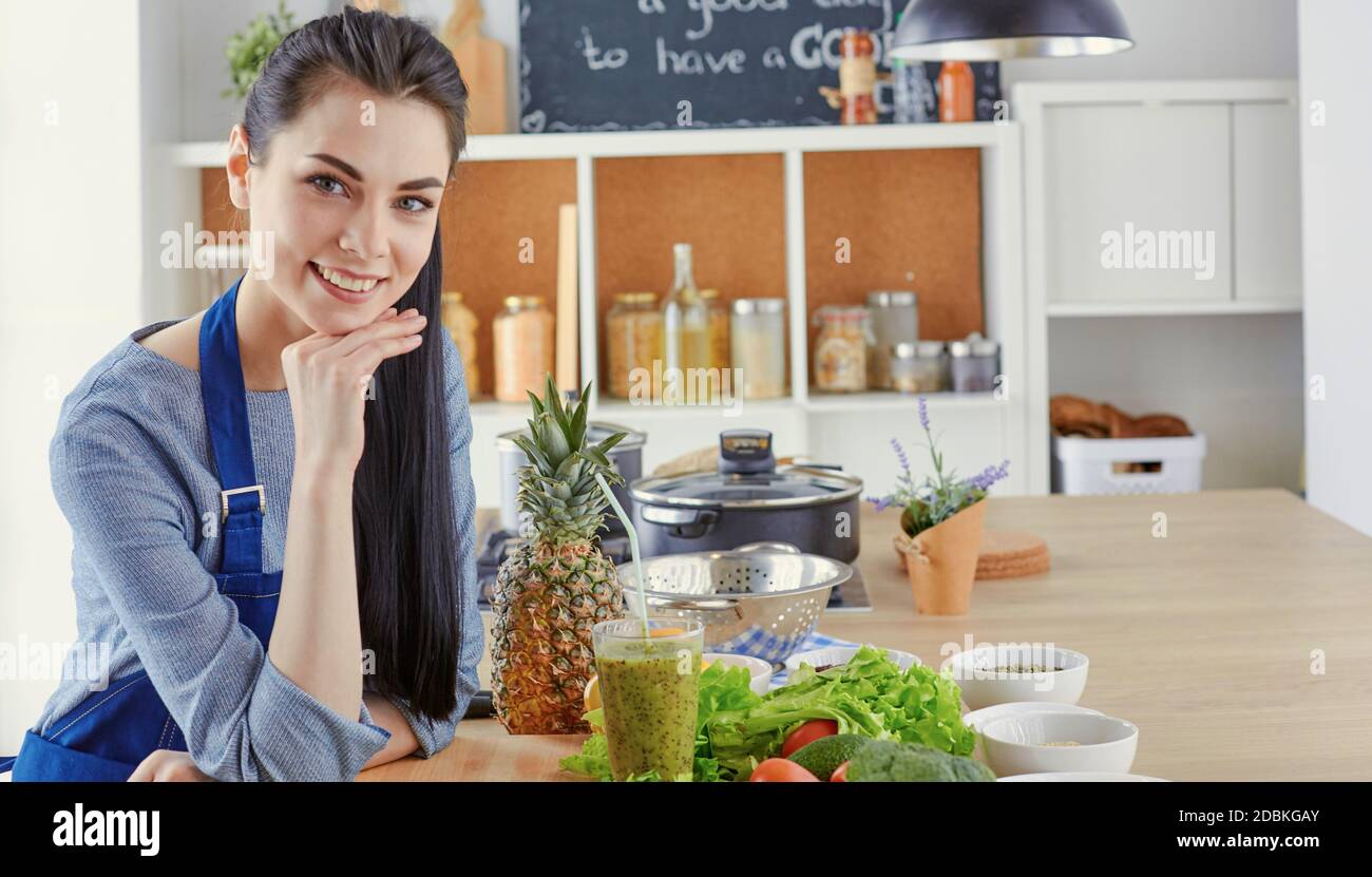 Beautiful woman in the kitchen, waiting with the front of the oven ...