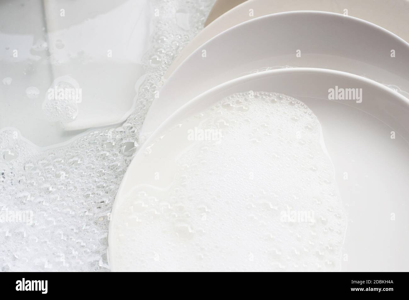 Dish washing, Dirty dishes soaking in kitchen sink Stock Photo - Alamy