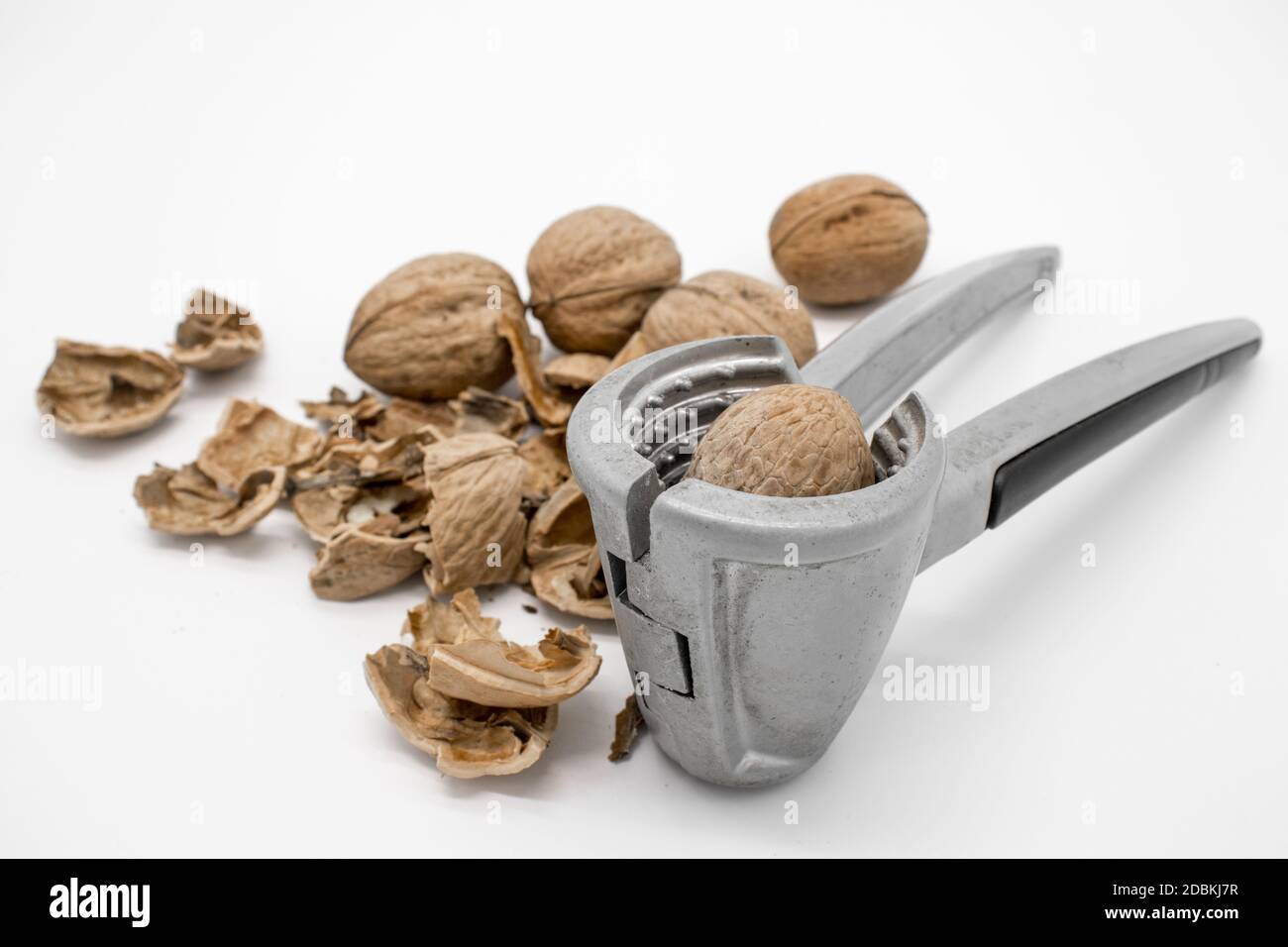 Walnuts on a white background, broken by a nutcracker Stock Photo - Alamy