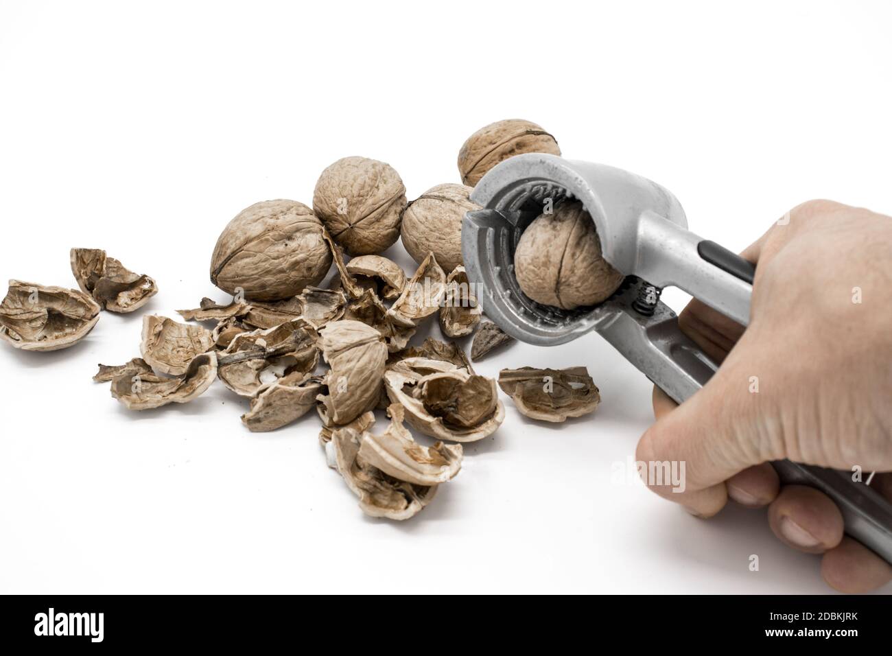 Walnuts on a white background, broken by a nutcracker Stock Photo - Alamy