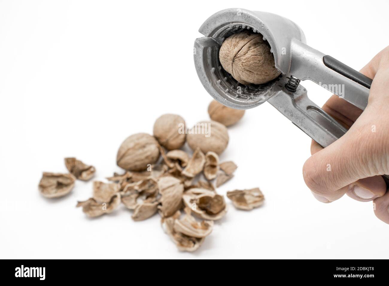 Walnuts on a white background, broken by a nutcracker Stock Photo - Alamy