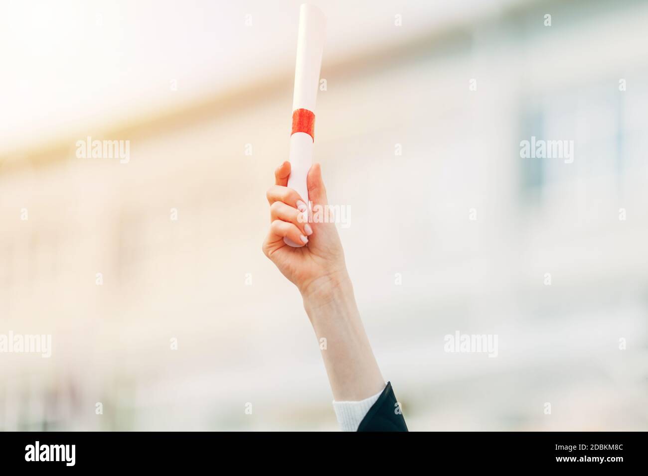 Close-up of a student's hand holding a graduation diploma. Concept of ...