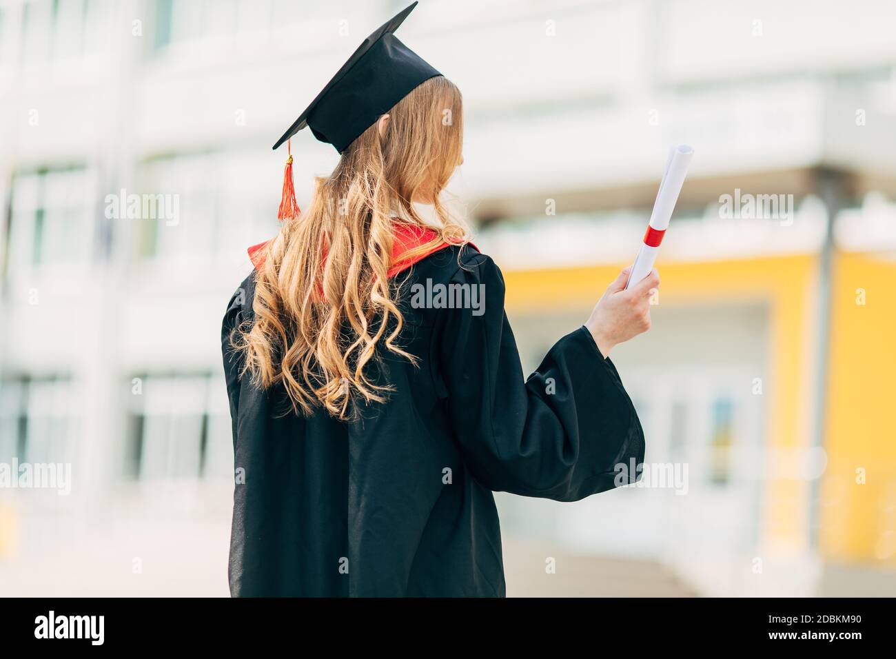 Graduation day, back view, a young student in a graduation cap and ...