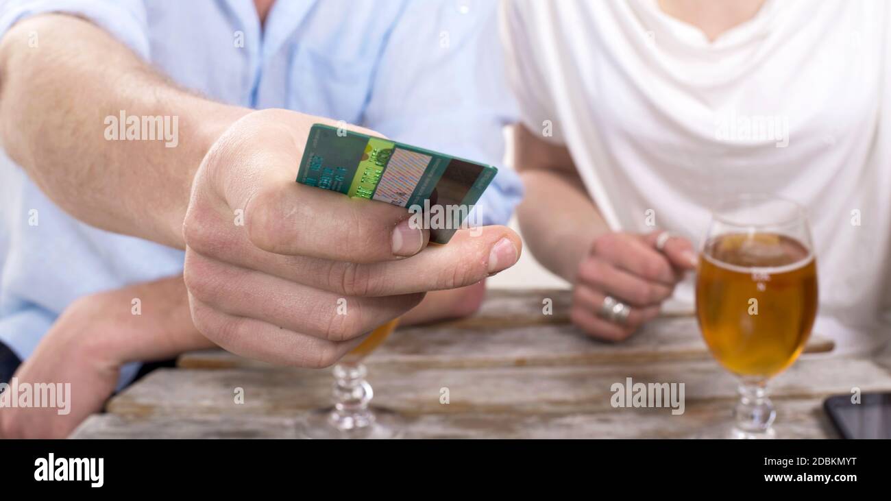 a young couple pays the drink bill with credit card Stock Photo - Alamy