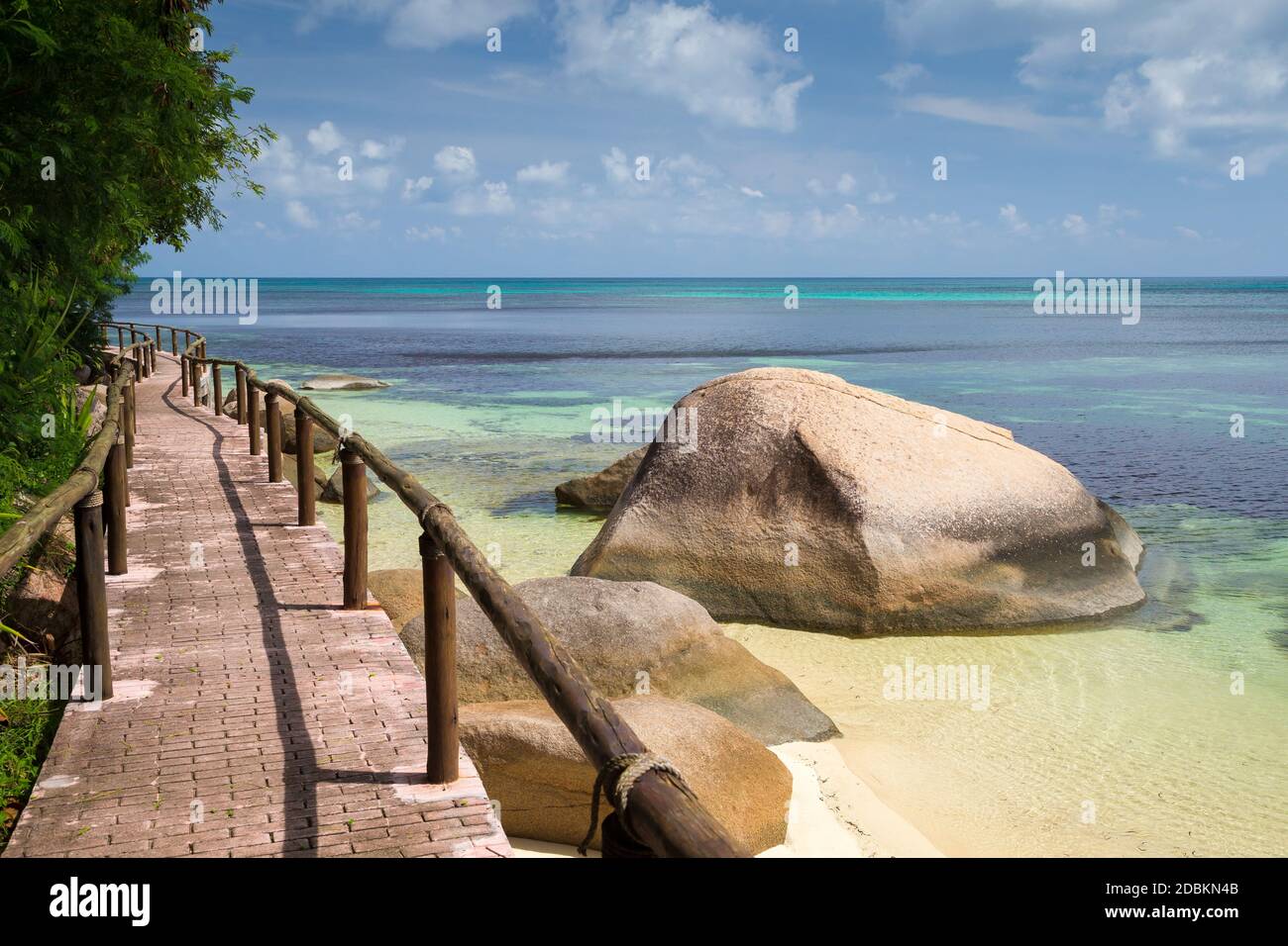 Pathway by the ocean with big stones and green plants Stock Photo - Alamy