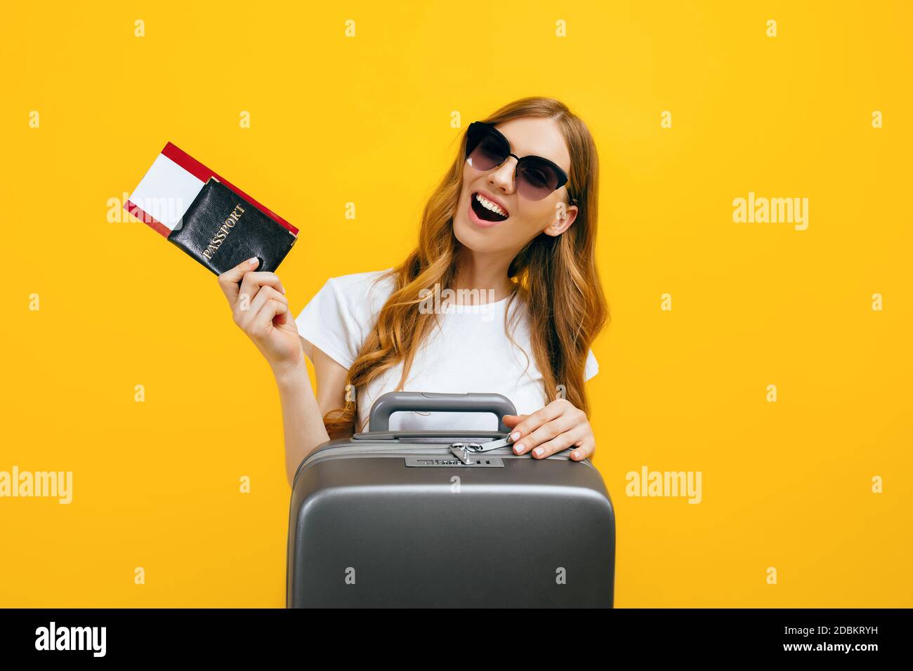Happy beautiful woman, girl with a suitcase and passport with tickets ...