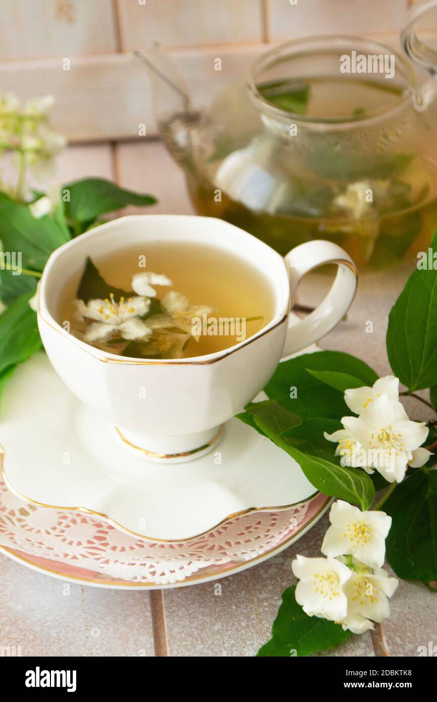 Jasmine tea with jasmine flowers on white wooden table background. Cup ...