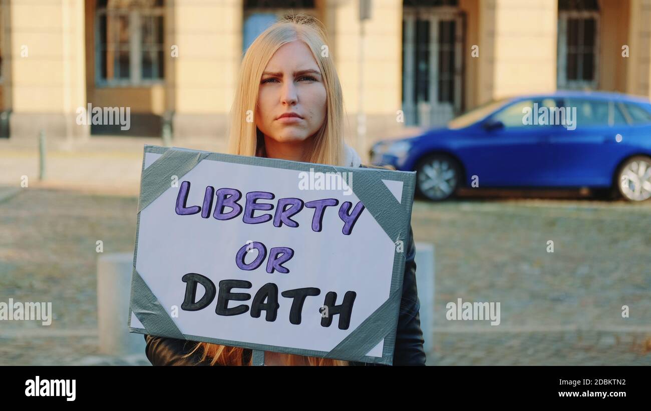Blonde woman with protest banner calling to choose liberty or death ...