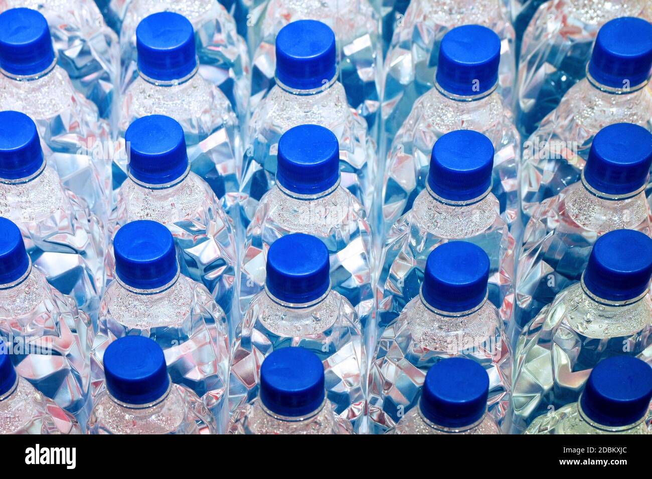 Bunch of plastic water bottles with blue lids Stock Photo - Alamy