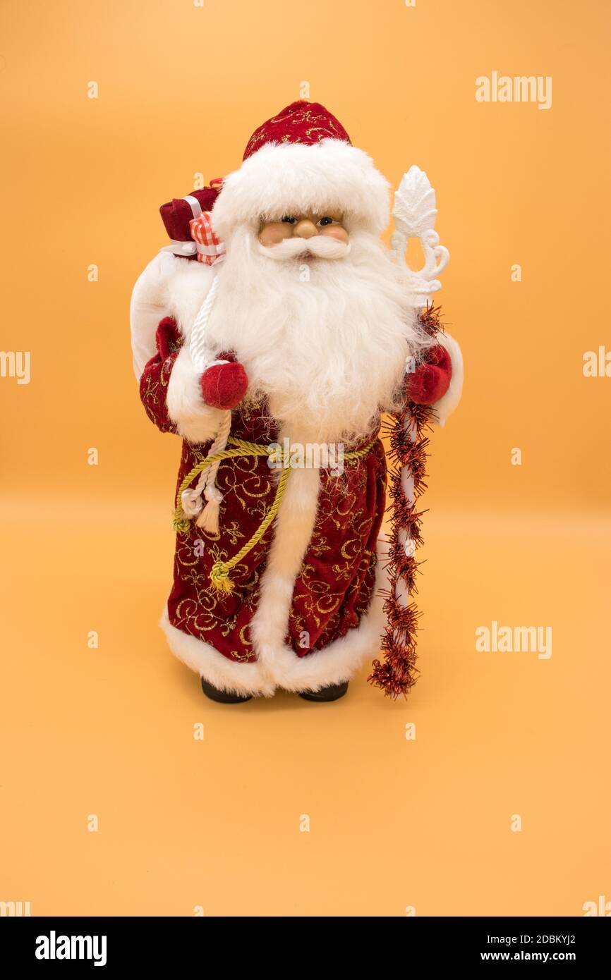 Ceramic statuette of Santa Claus in a red coat holding a staff isolated ...