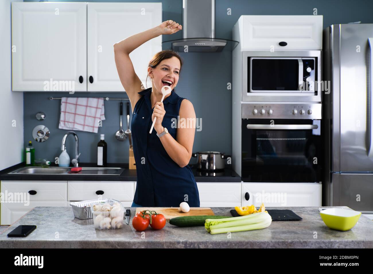 Young woman singing into whisk hi-res stock photography and images - Alamy