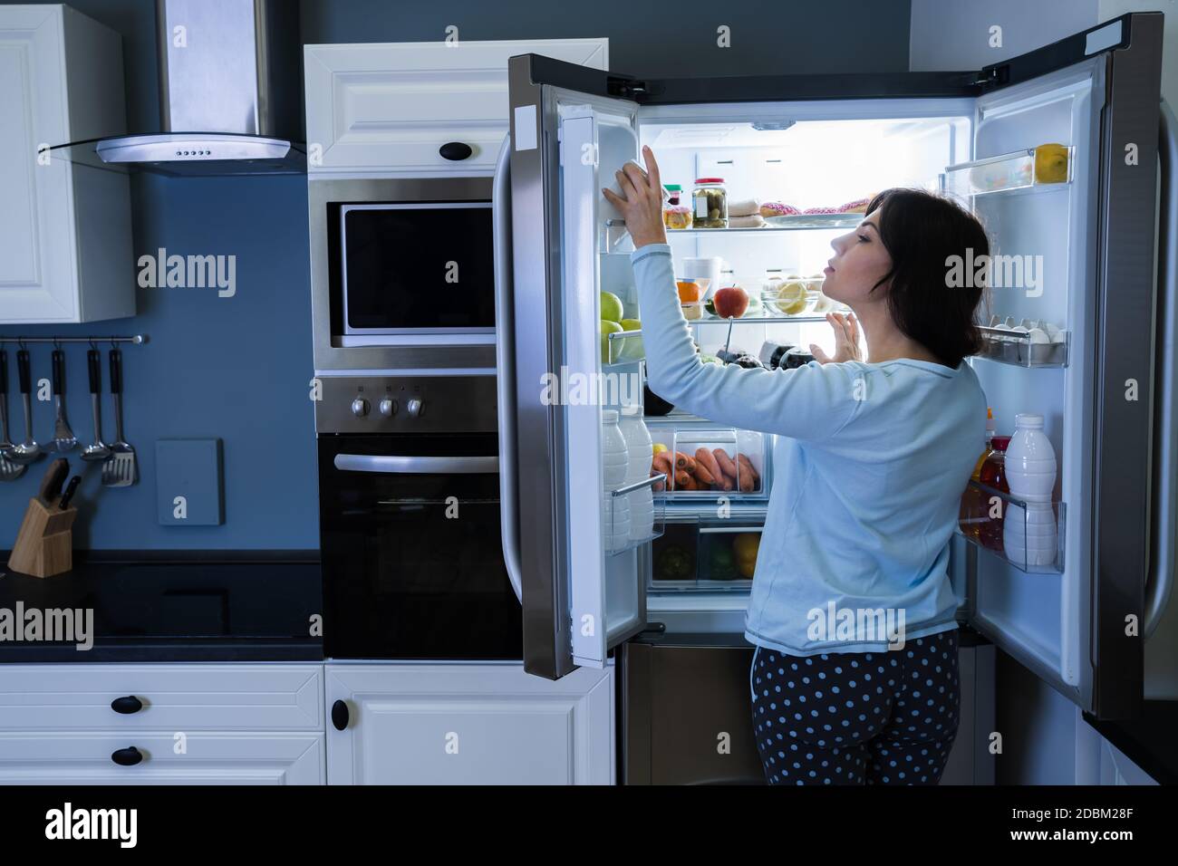Hungry Woman At Night With Open Fridge Stock Photo - Alamy