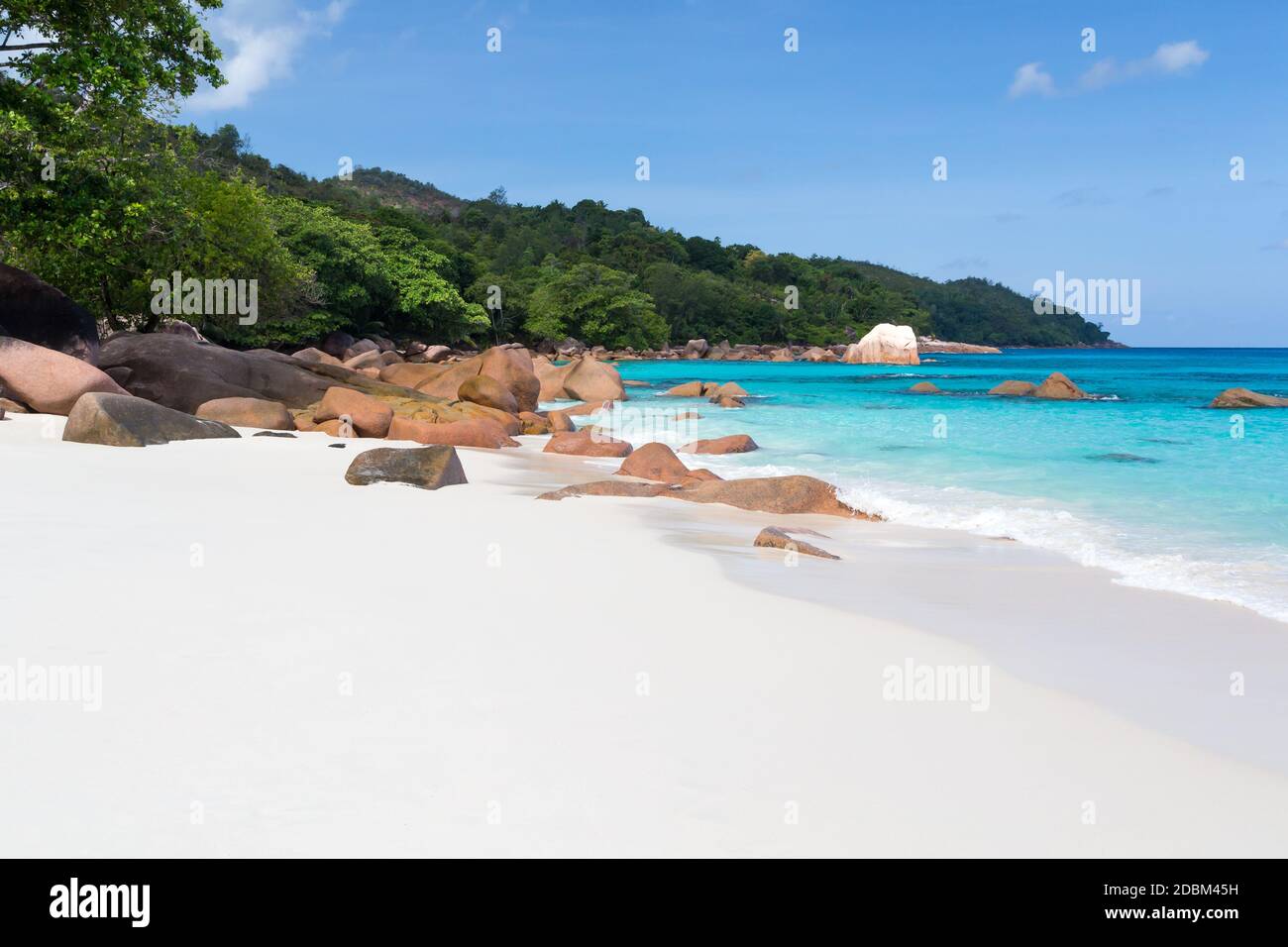 The beach of the Seychelles with blue water and stones Stock Photo - Alamy