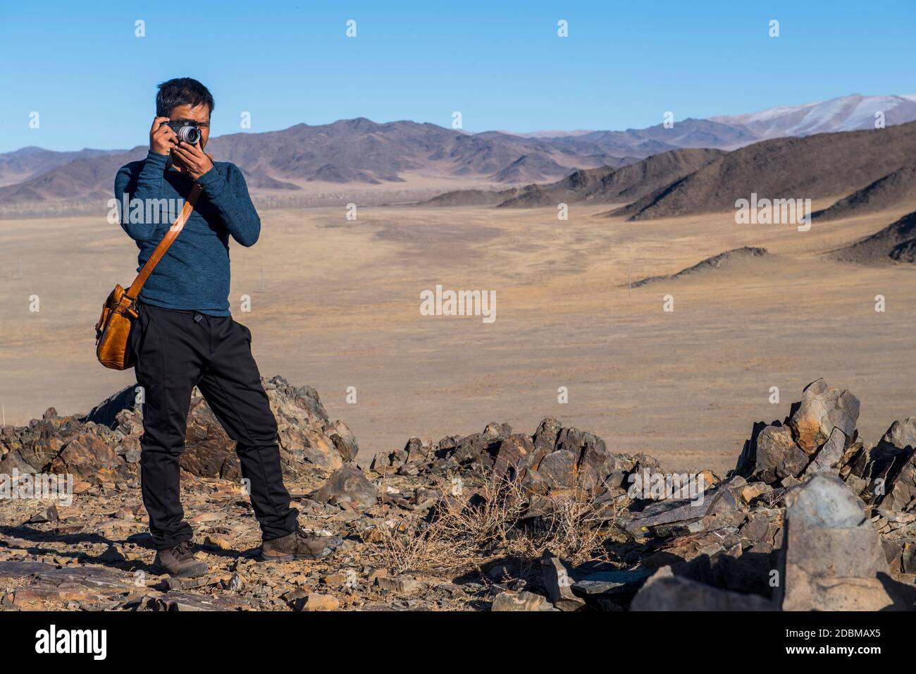 Man photographing barren landscape, Olgiy, Bayan-Olgiy, Mongolia Stock ...