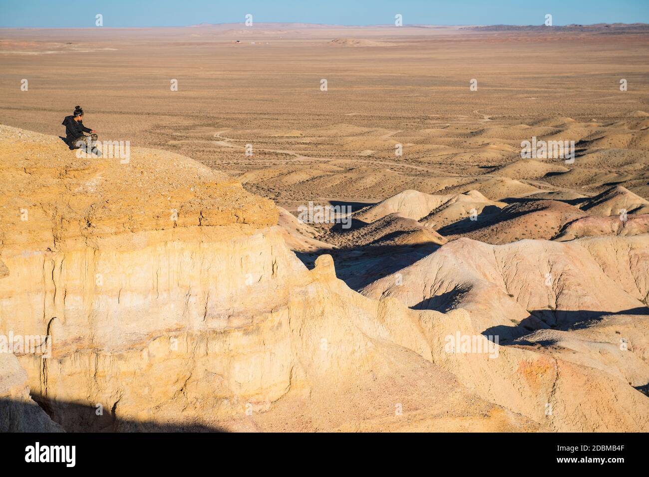 Woman sitting at edge of Flaming Cliffs, Mongolia Stock Photo - Alamy