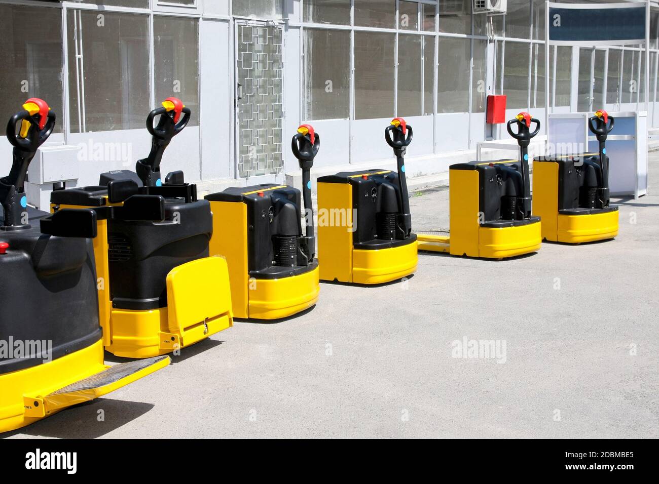Yellow industrial cargo pallet transporters in line Stock Photo - Alamy