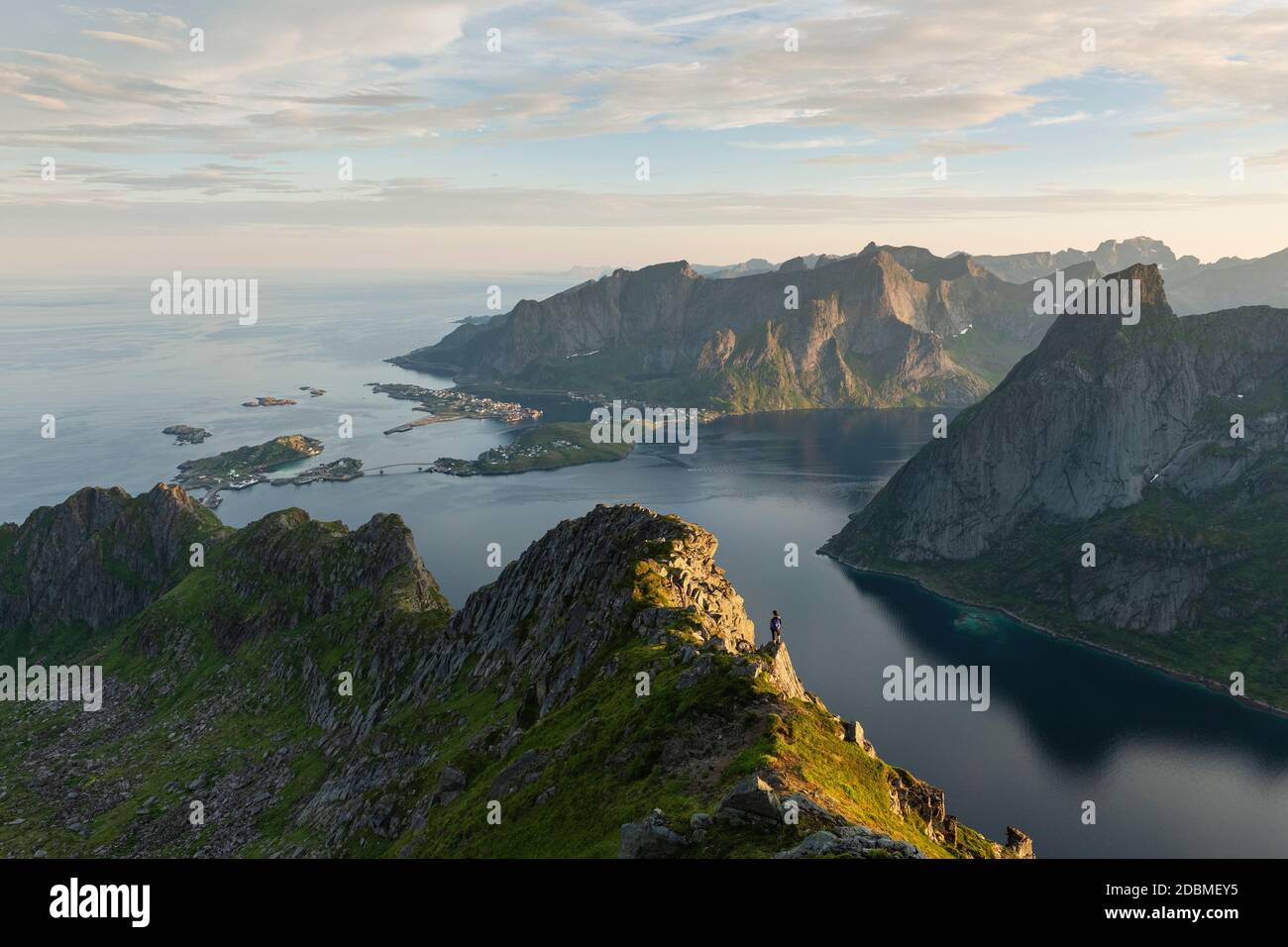 Female hiker on mountain ridge with Reine and Reinefjord in the ...