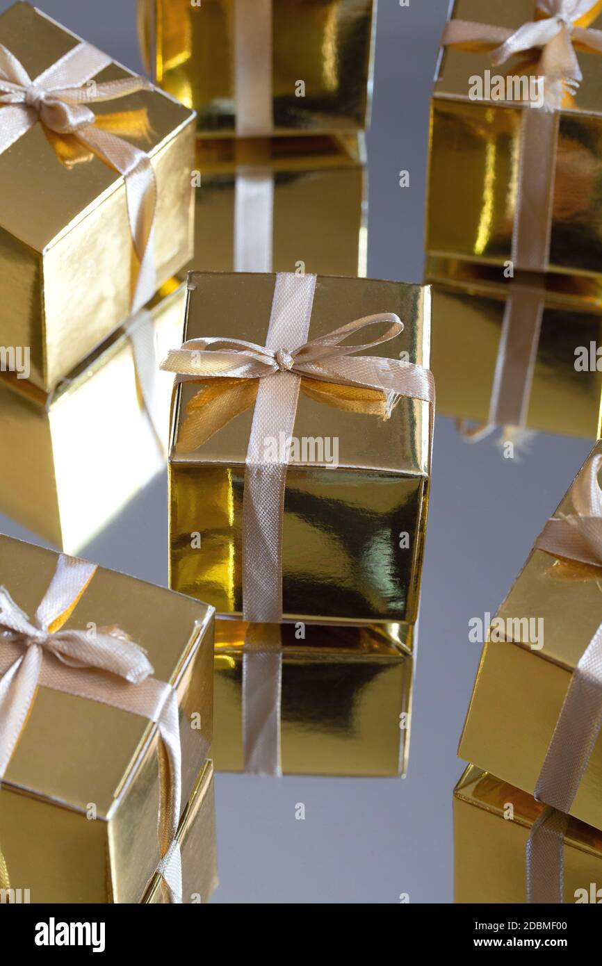 Group of gold sparkling gift boxes on grey background with reflection ...