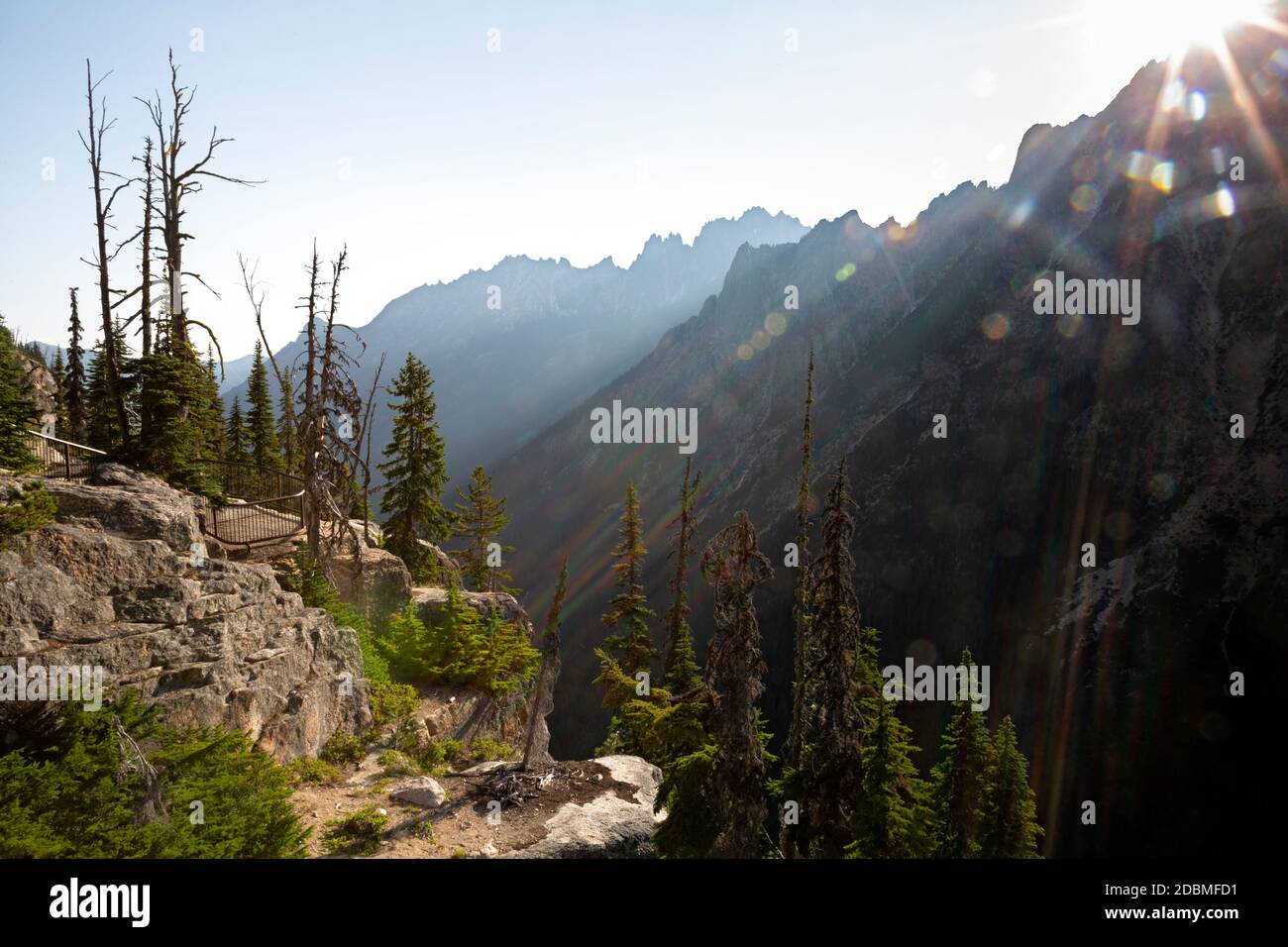 WA18159-00...WASHINGTON - The sun rising over a rugged ridge viewed ...