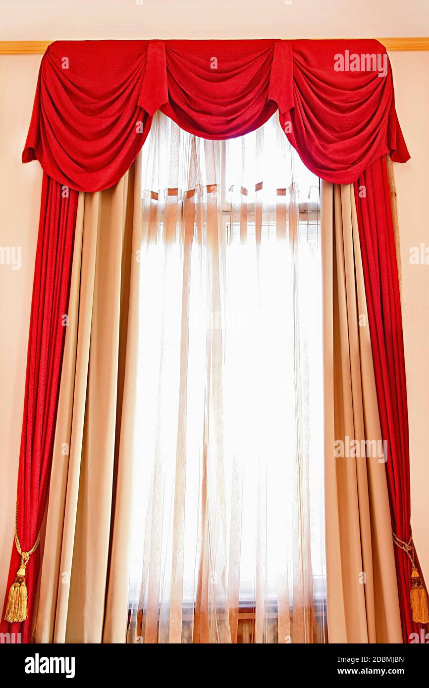 Red long drapery at big bright window Stock Photo - Alamy