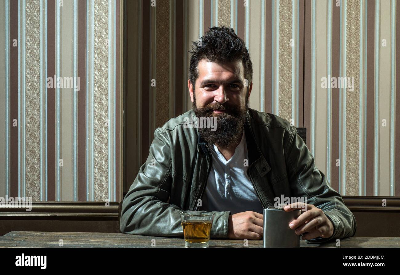 Handsome smiling man drinking alone. Bearded brutal hipster man ...