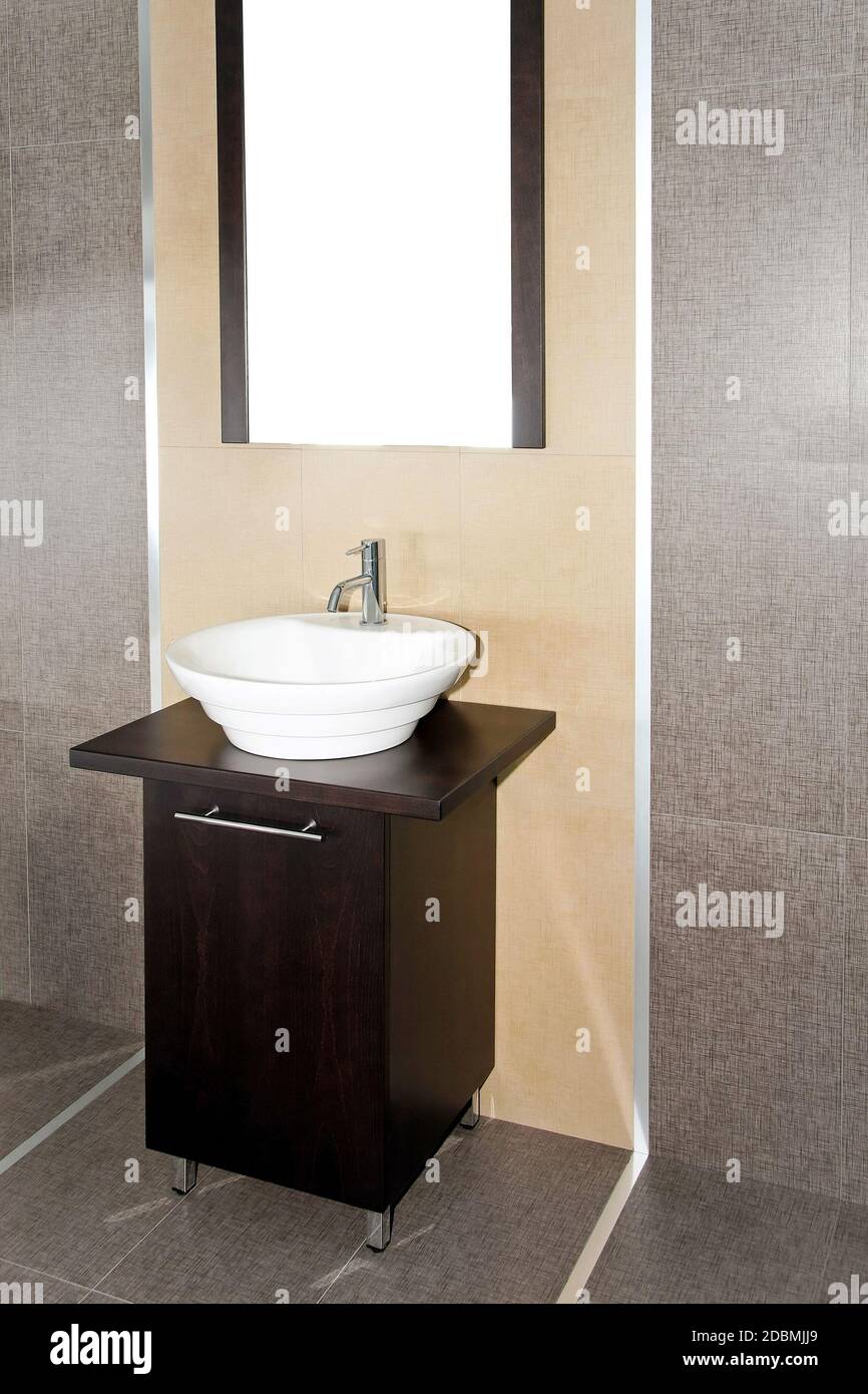 Contemporary lavatory with brown cabinet and mirror Stock Photo - Alamy