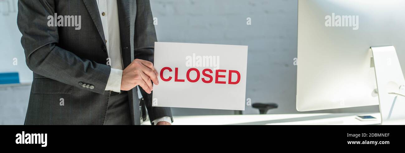Cropped view of businessman holding sign with closed lettering, while ...