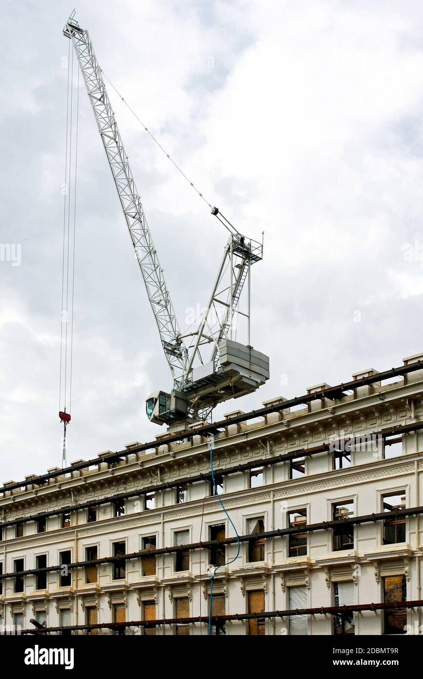 Exterior of building reconstruction with tall crane Stock Photo - Alamy