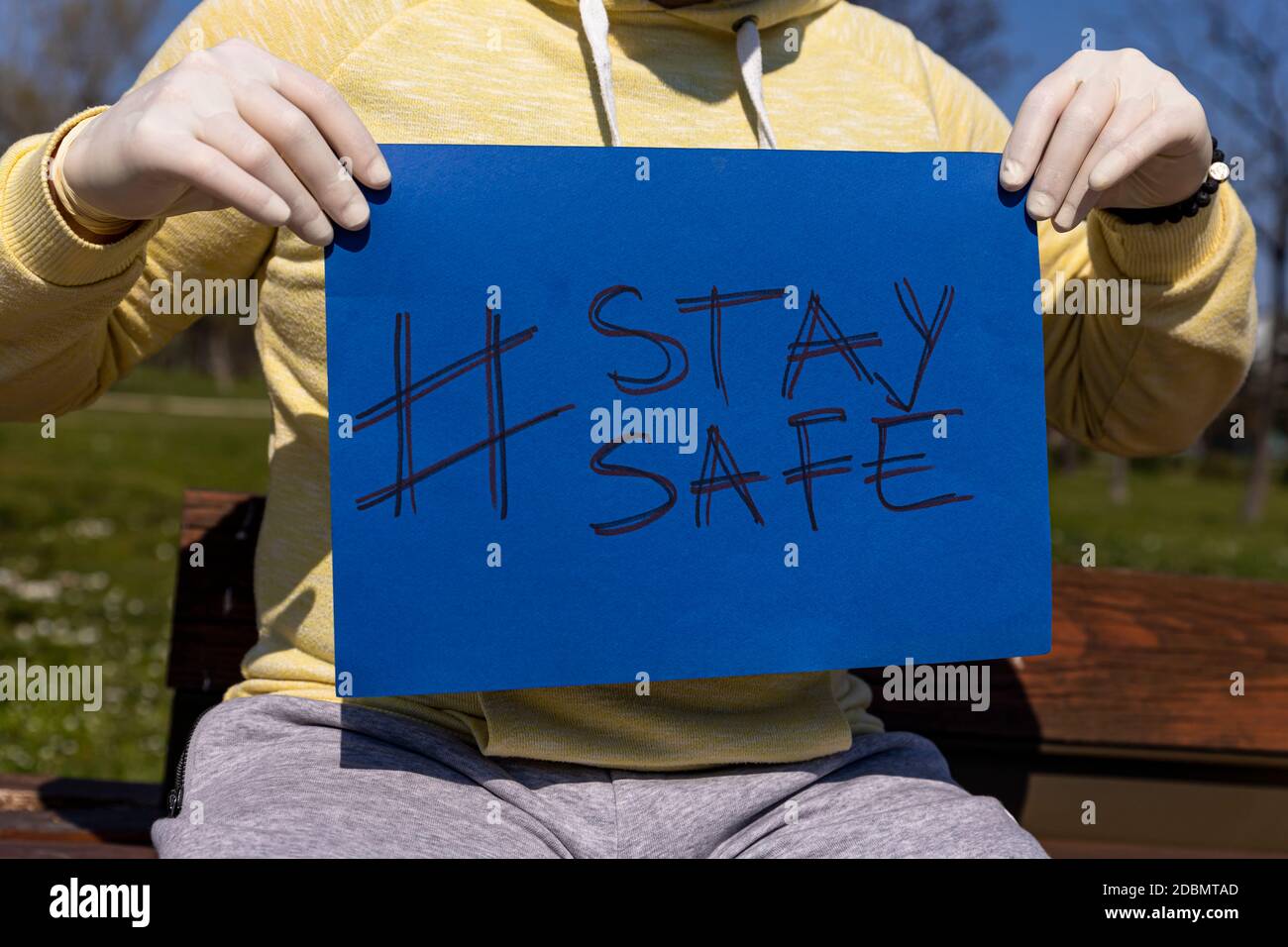 Stay safe sign on blue chroma key paper held by a man in surgical ...