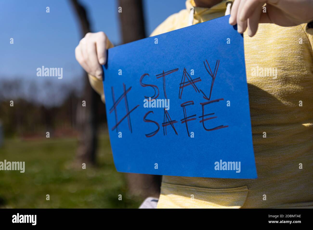 Stay safe sign on blue chroma key paper held by a man in surgical ...