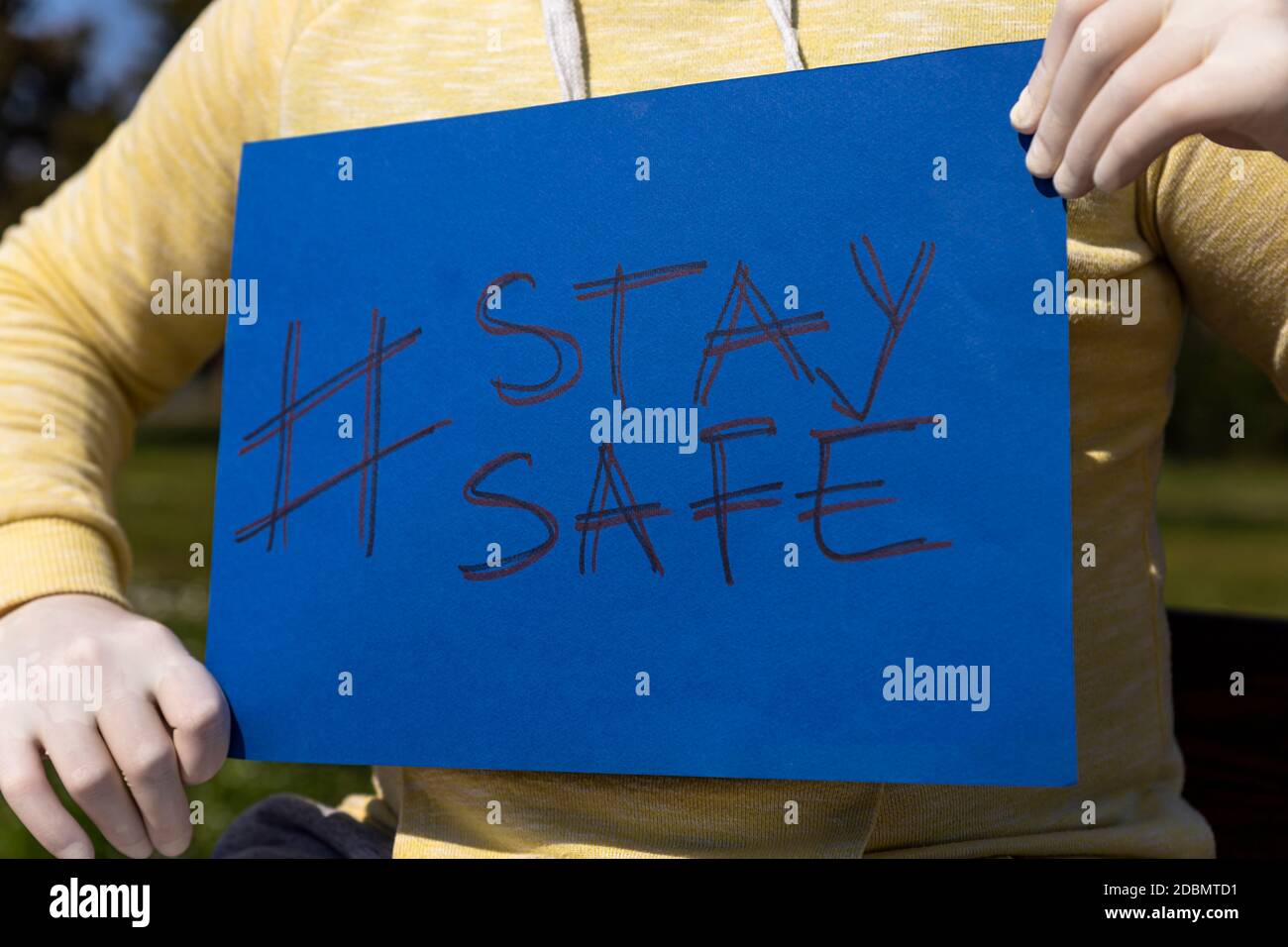Stay safe sign on blue chroma key paper held by a man in surgical ...