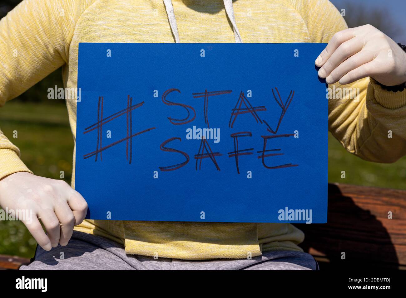 Stay safe sign on blue chroma key paper held by a man in surgical ...