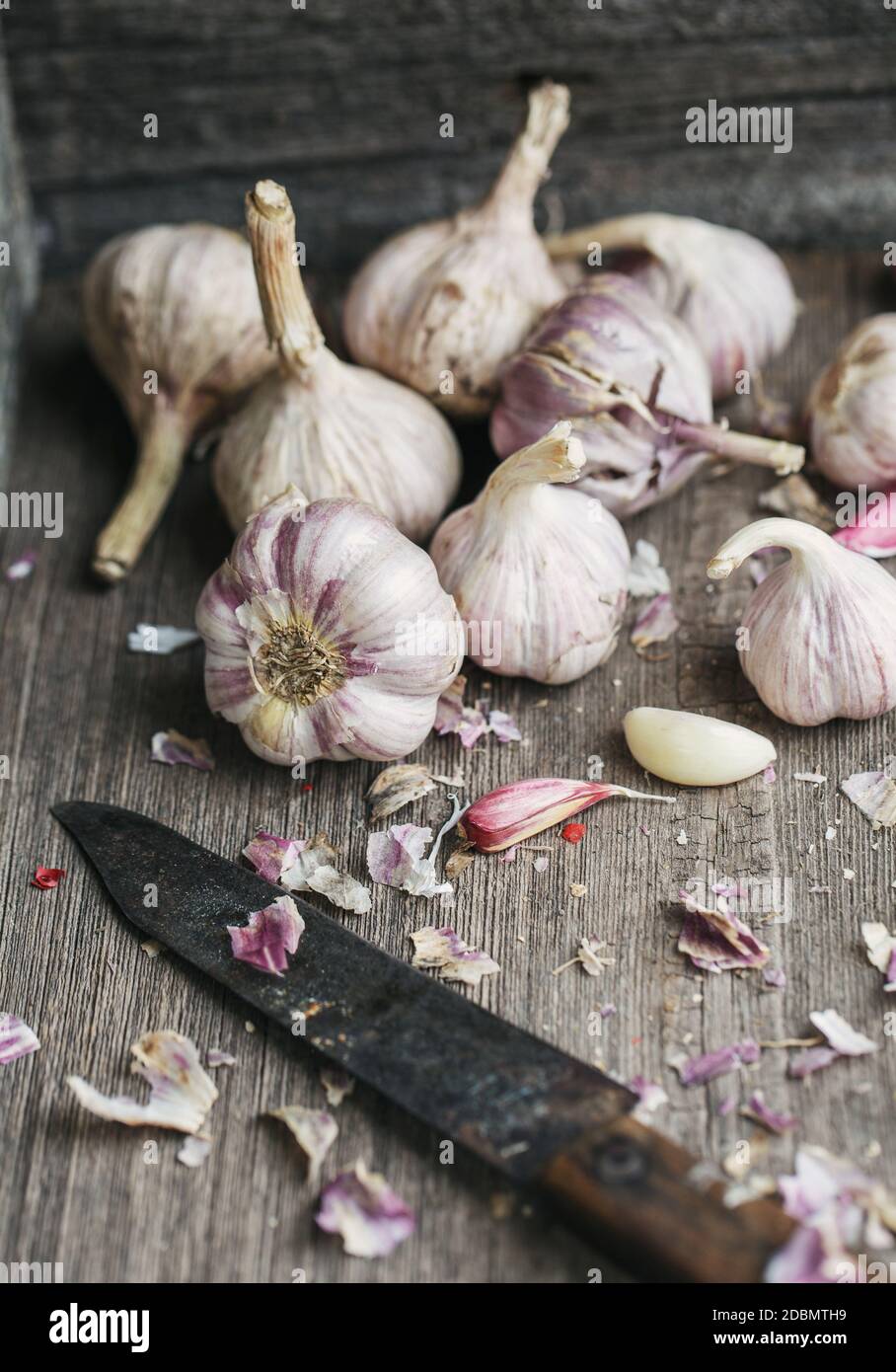 The process of cleaning garlic. Garlic and leaves on wooden background ...