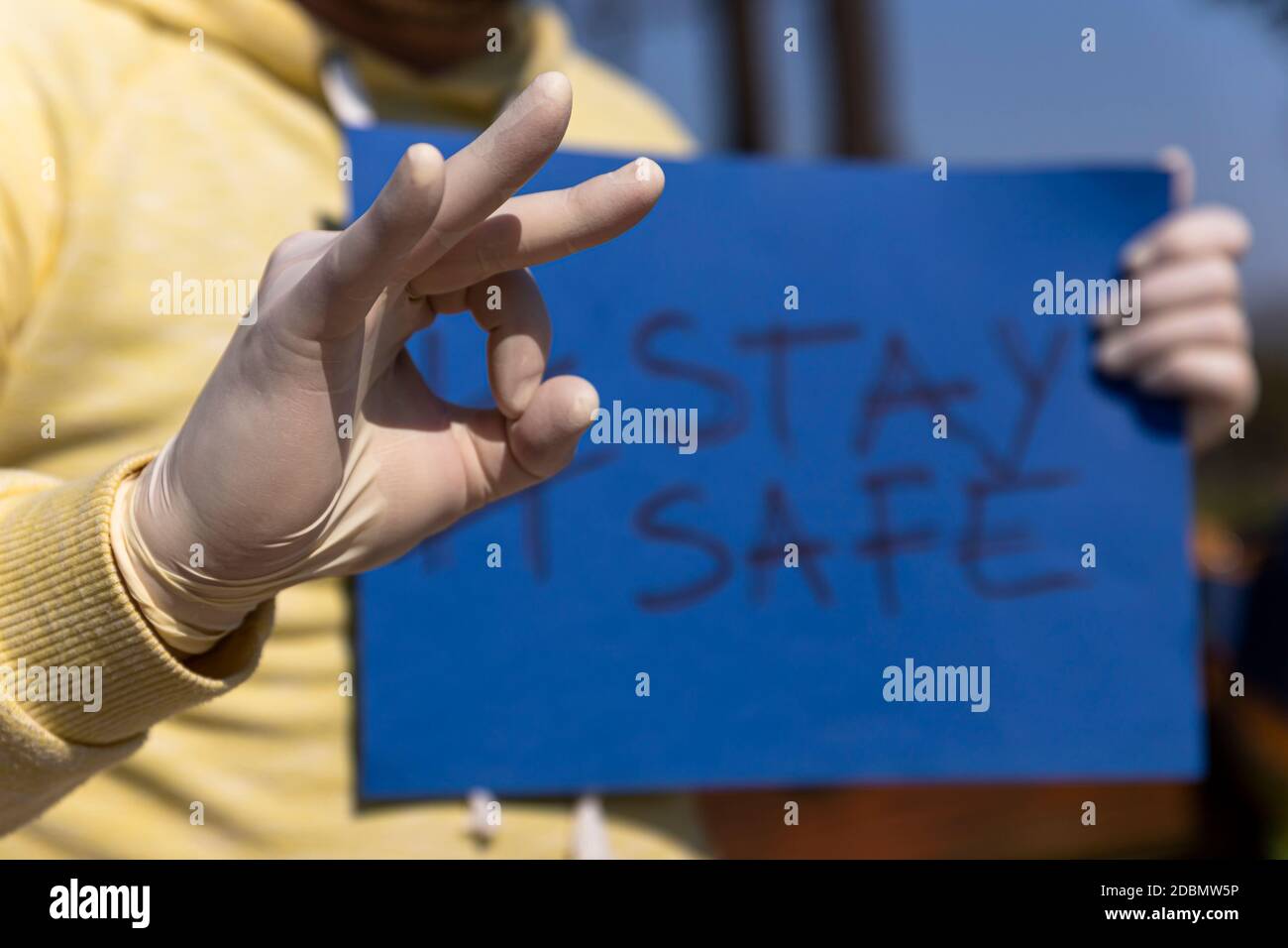Stay safe sign on blue chroma key paper held by a man in surgical ...