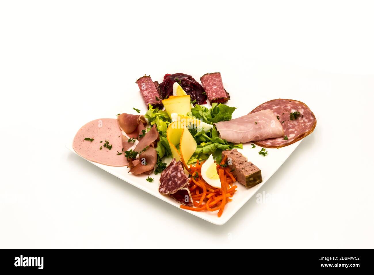 Plate of cold cuts and cheese with raw vegetables on a square plate on ...