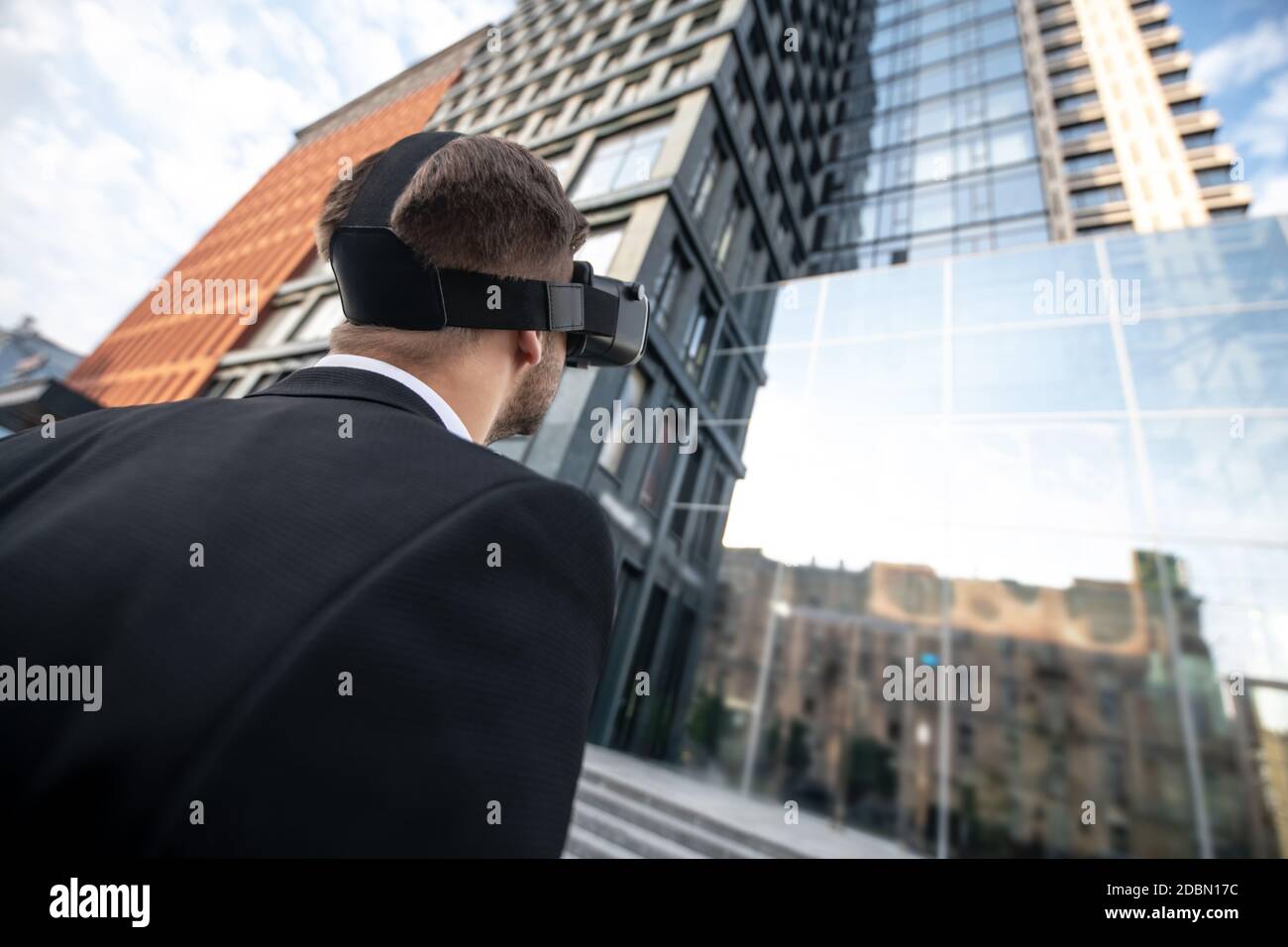 Man wearing a black suit in vr glasses looking at the building Stock ...