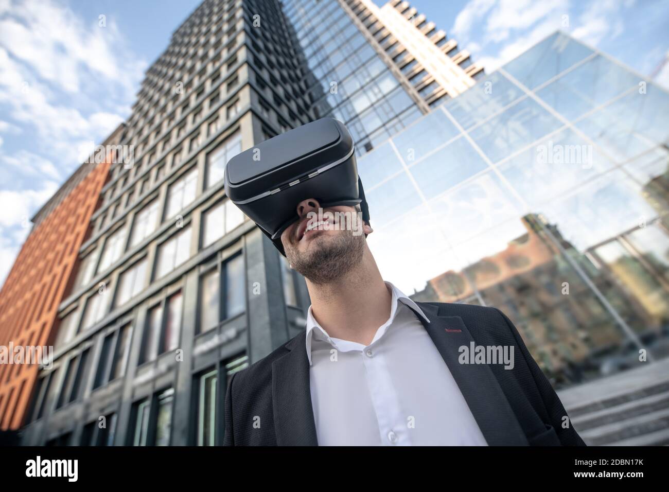 Man in black suit wearing vr glasses and looking enjoyed Stock Photo ...
