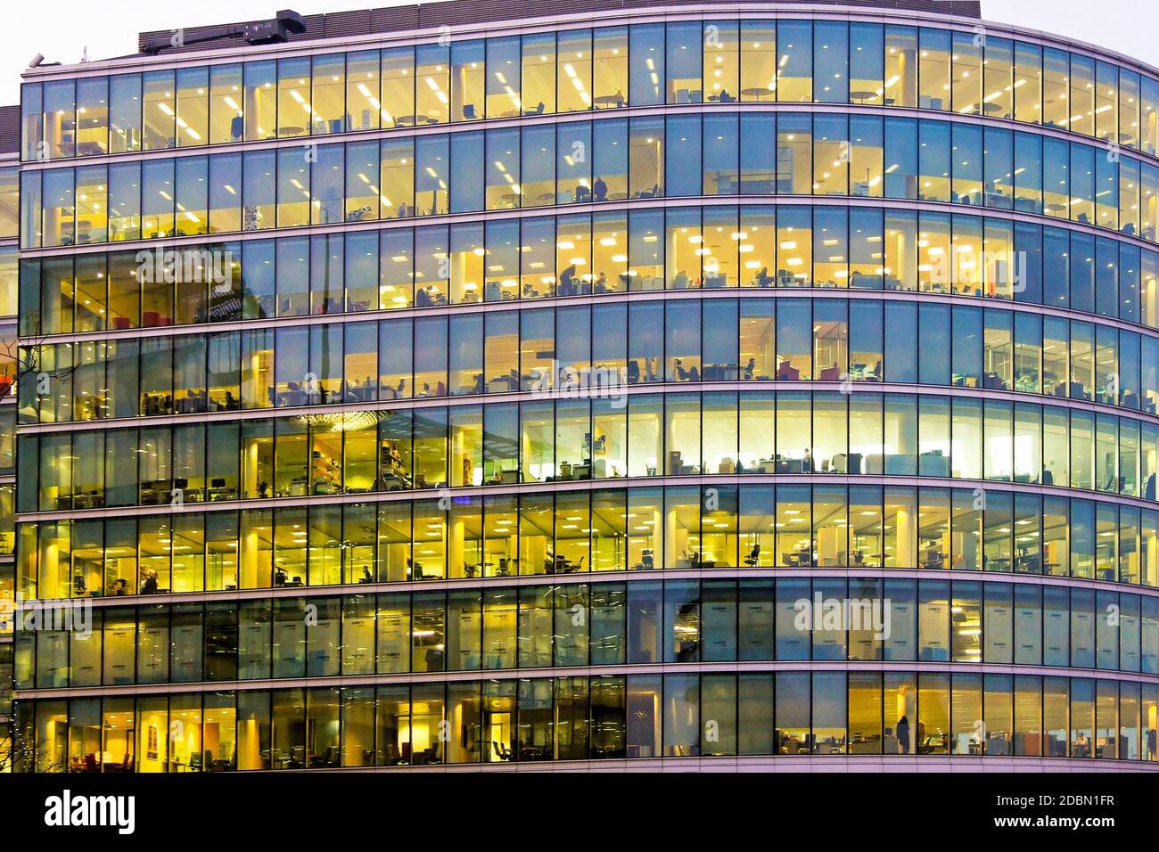 Side view of glass corporate building at work time Stock Photo - Alamy