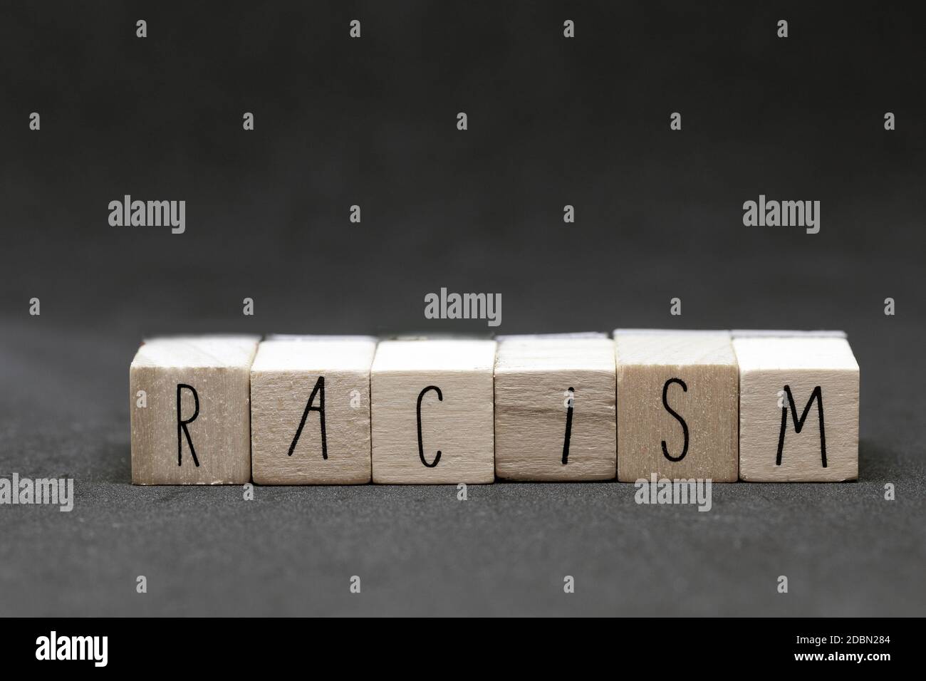 Wooden cubes with the word racism on dark background, black lives ...