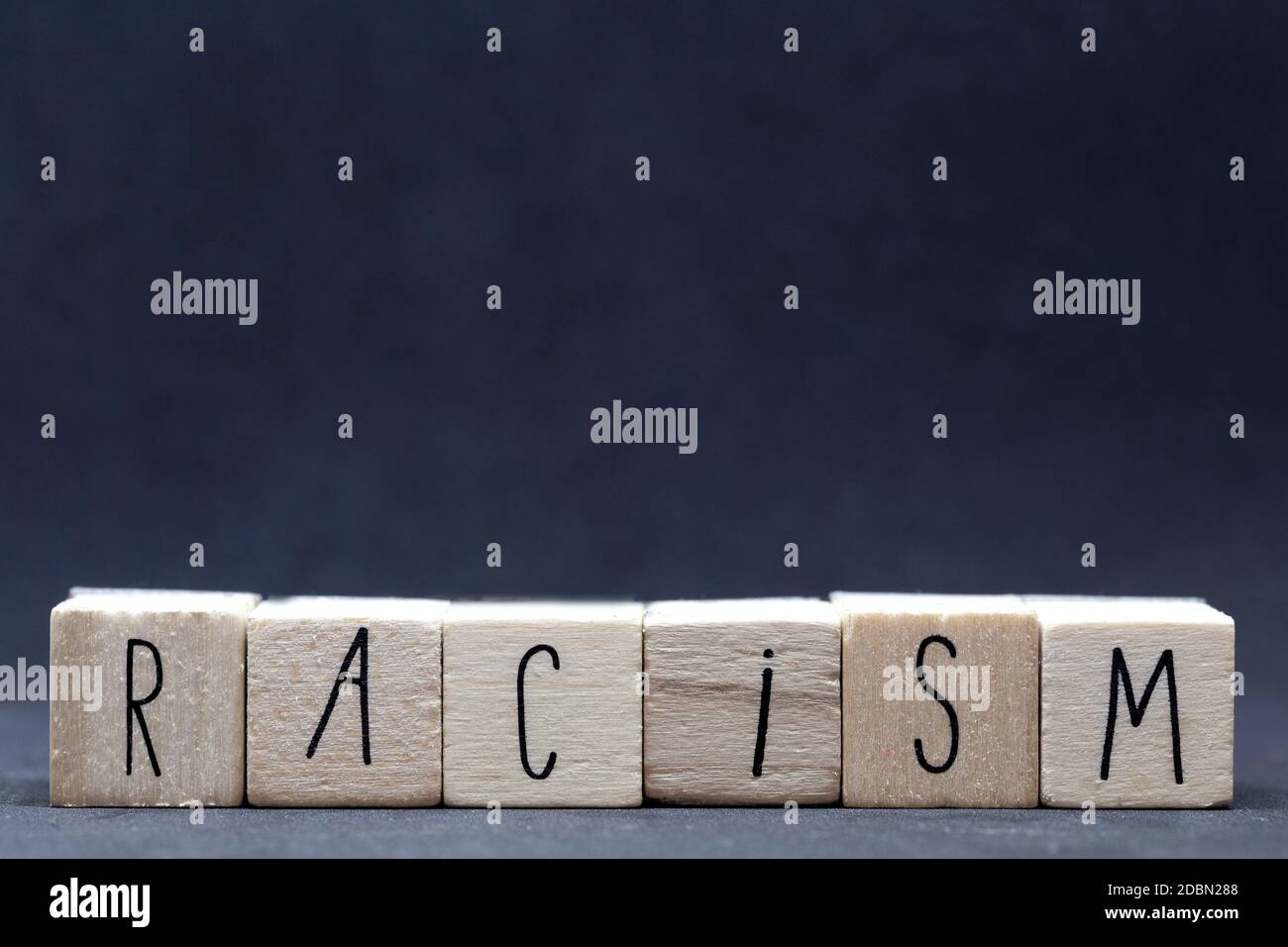 Wooden cubes with the word racism on dark background, black lives ...
