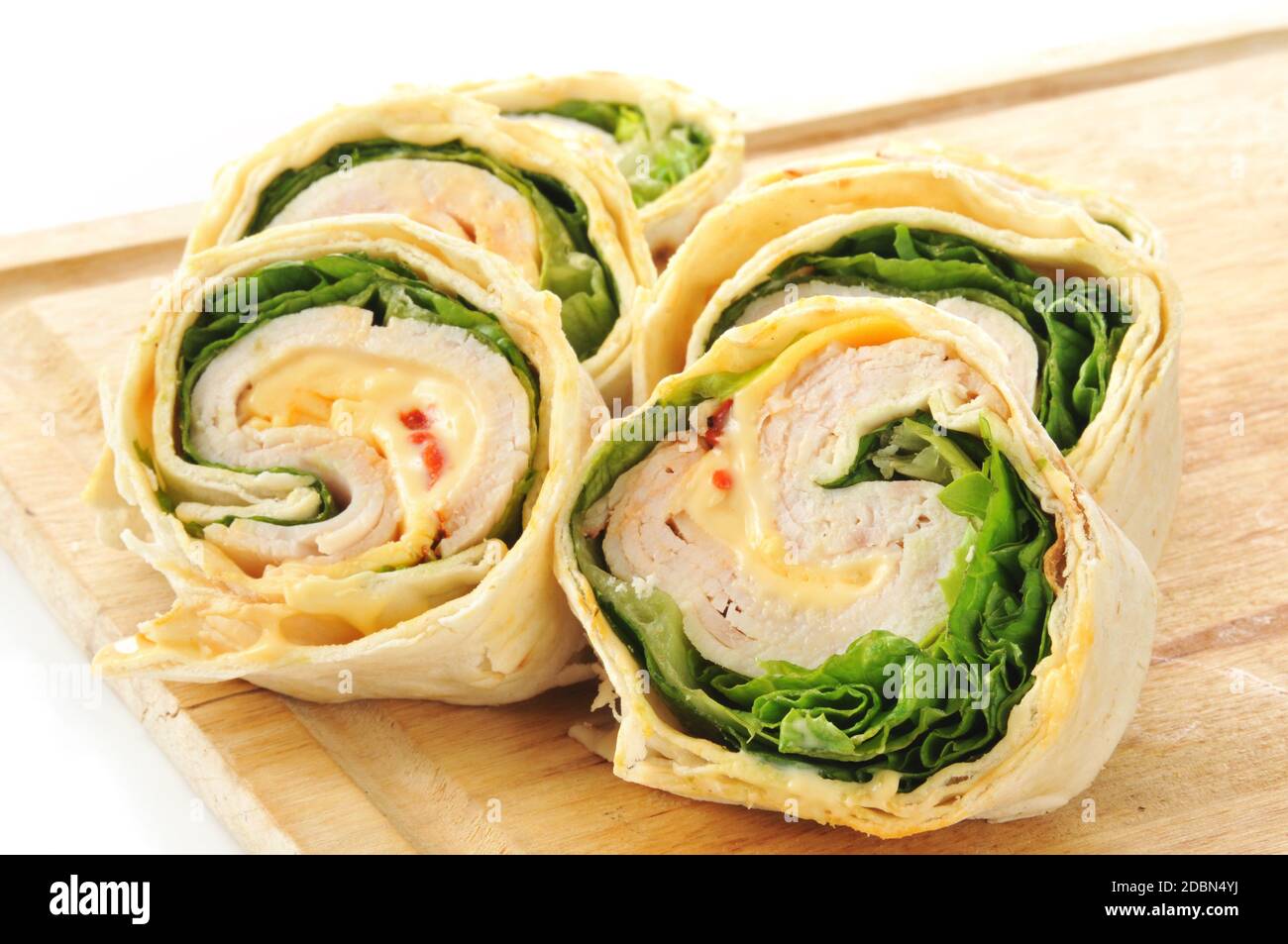 A turkey and cheese wrap sandwich sliced on a cutting board Stock Photo ...