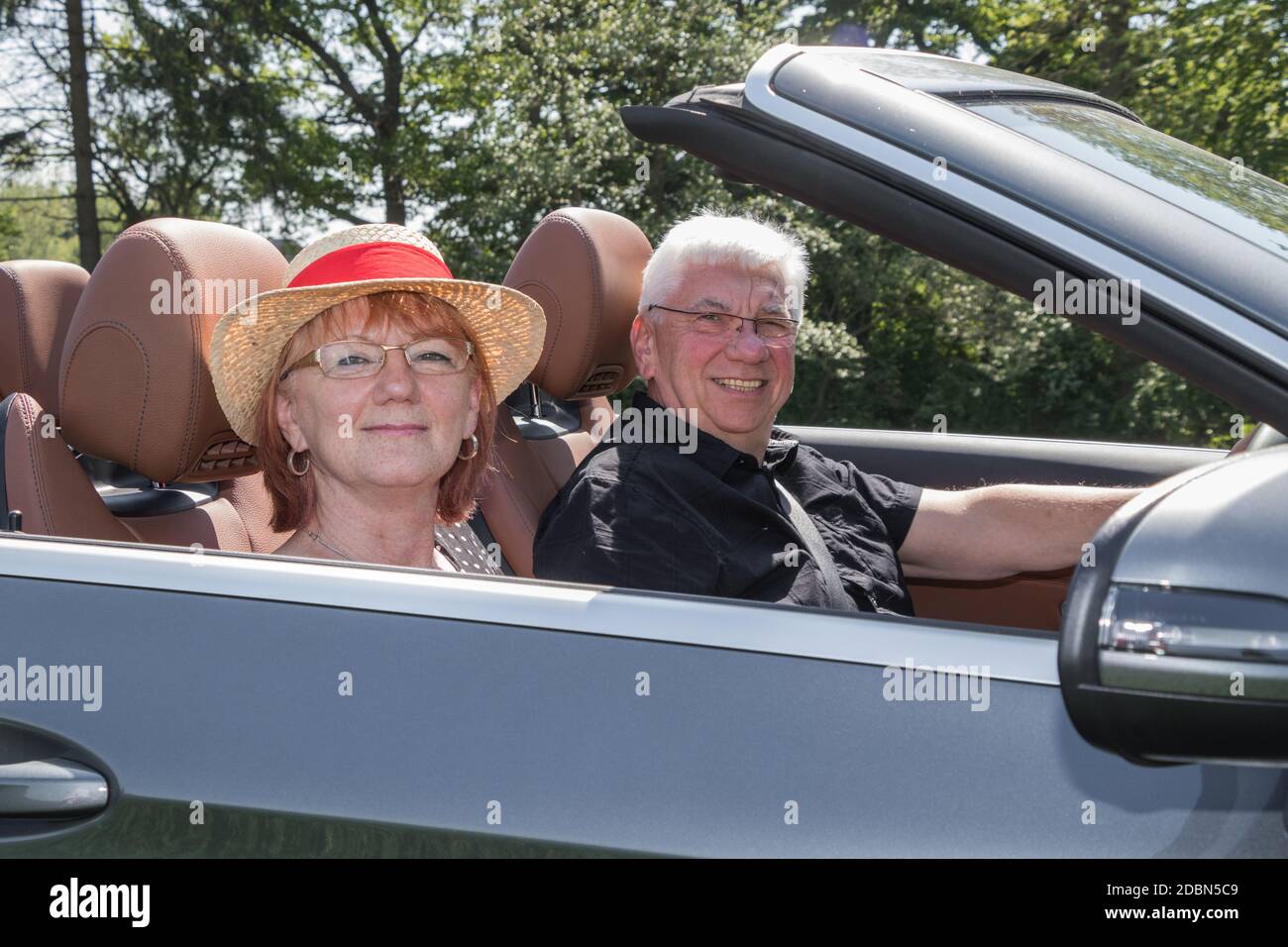Older couple drives with a luxury convertible car Stock Photo - Alamy