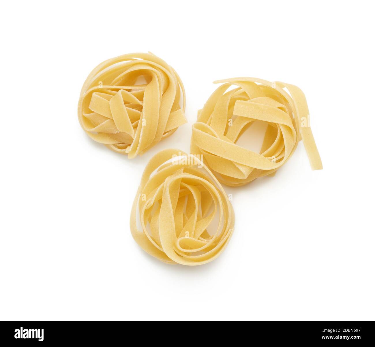 twisted pasta in a round fettuccine nest on a white isolated background ...
