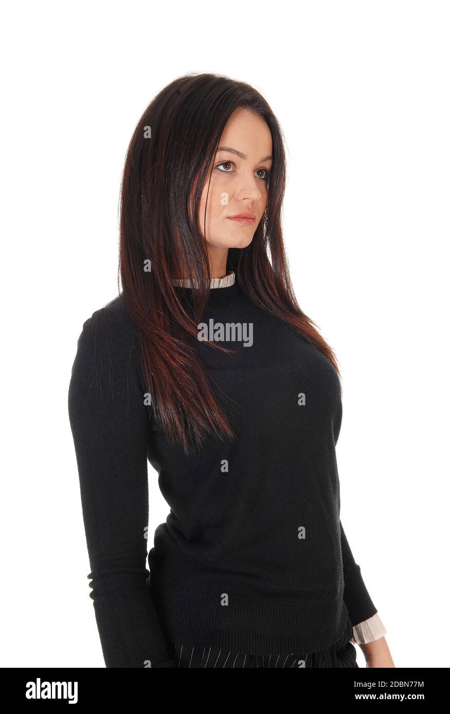 A gorgeous young woman standing in profile in a back sweater, looking ...