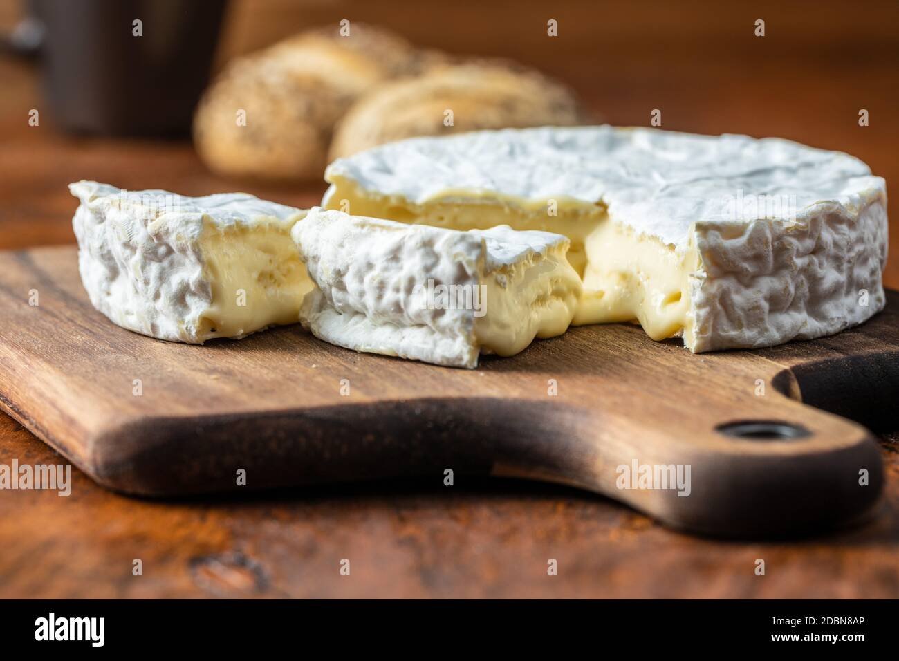 Brie cheese. White soft cheese with white mold on cutting board Stock ...