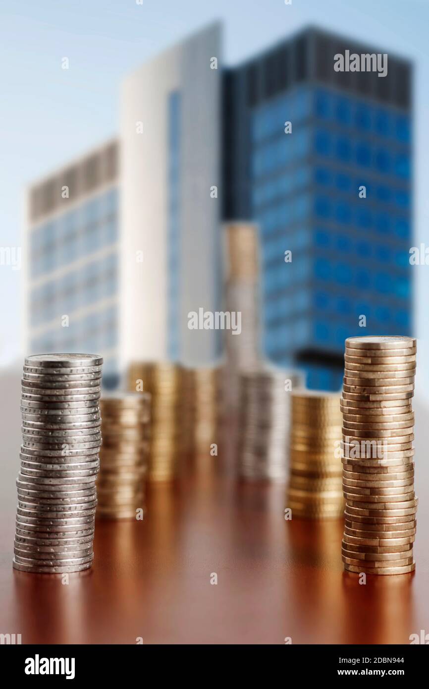 Image composition of stacked euro coins in front of a skyscraper with a ...
